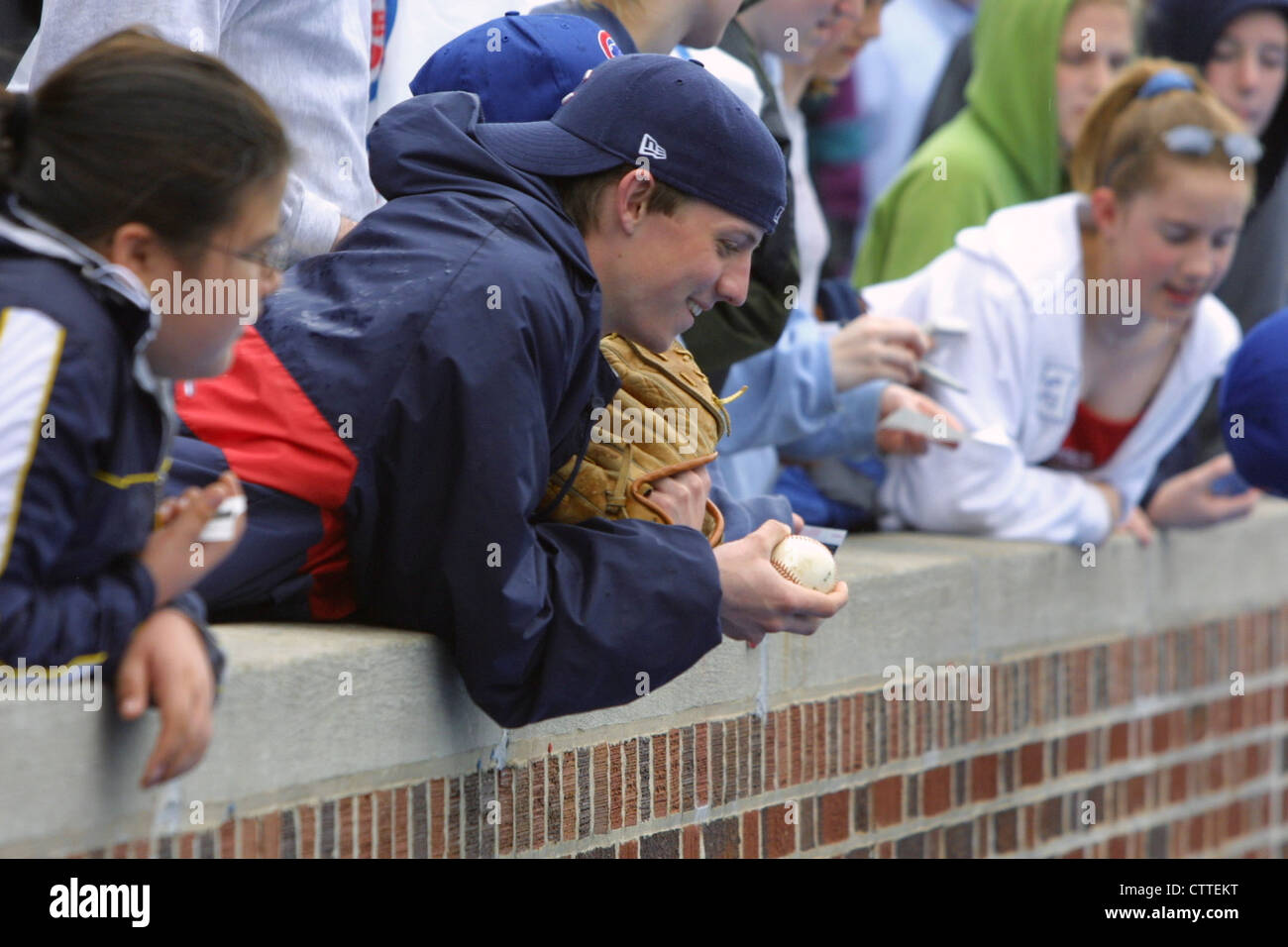 A fan reacts with a smile after getting a ball autographed by a member ...