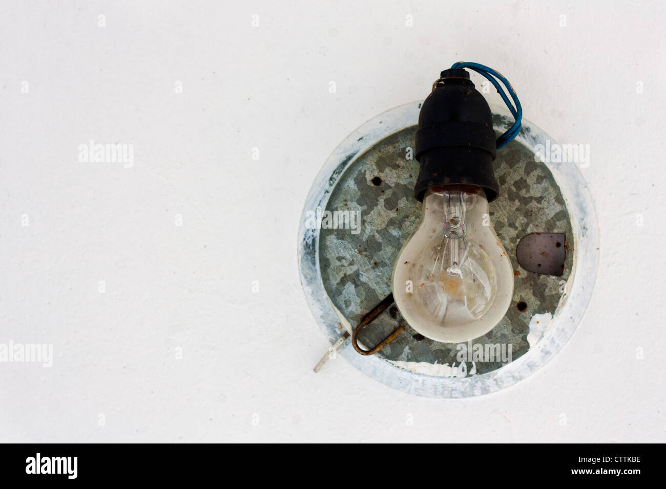 Old,dirty electric bulb against a white wall Stock Photo - Alamy