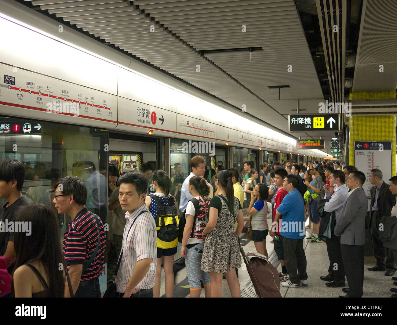 Commuters and passengers waiting at a Hong Kong MTR station platform ...