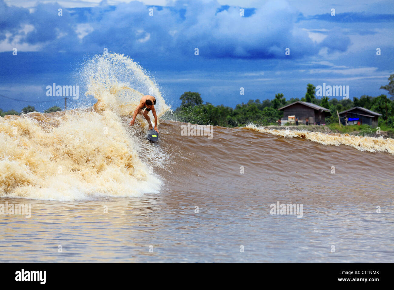 Australian Mikey Barber surfing a tidal bore wave on a Sumatran river ...