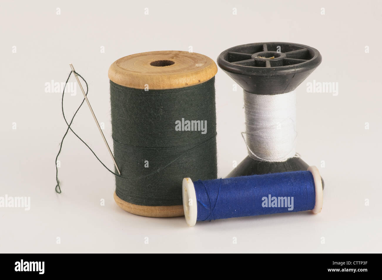 Spool of thread with needle on white background Stock Photo - Alamy