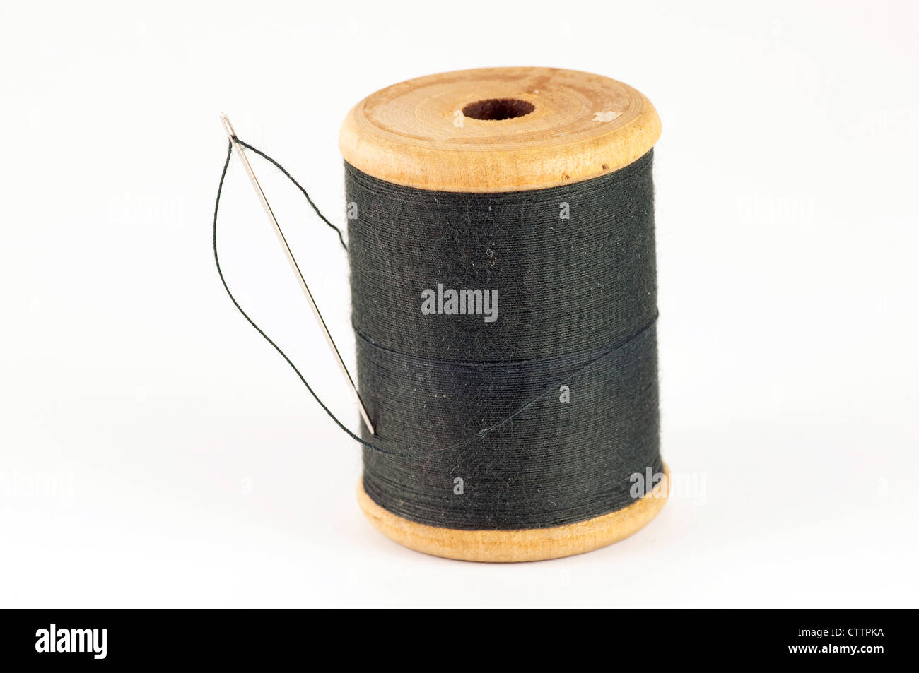 Spool of thread with needle on white background Stock Photo - Alamy