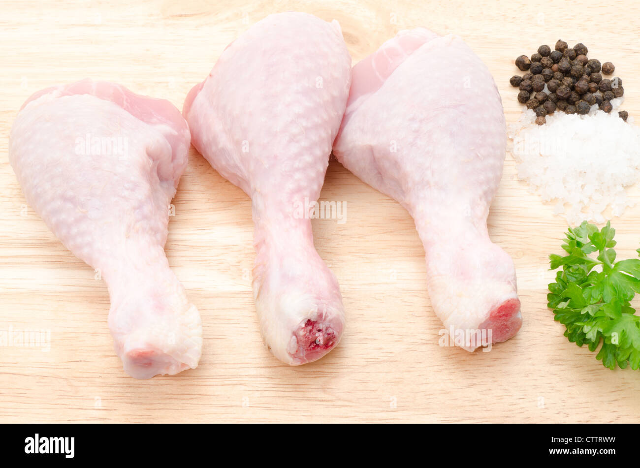 Three uncooked chicken legs on a wooden cutting - studio shot Stock ...