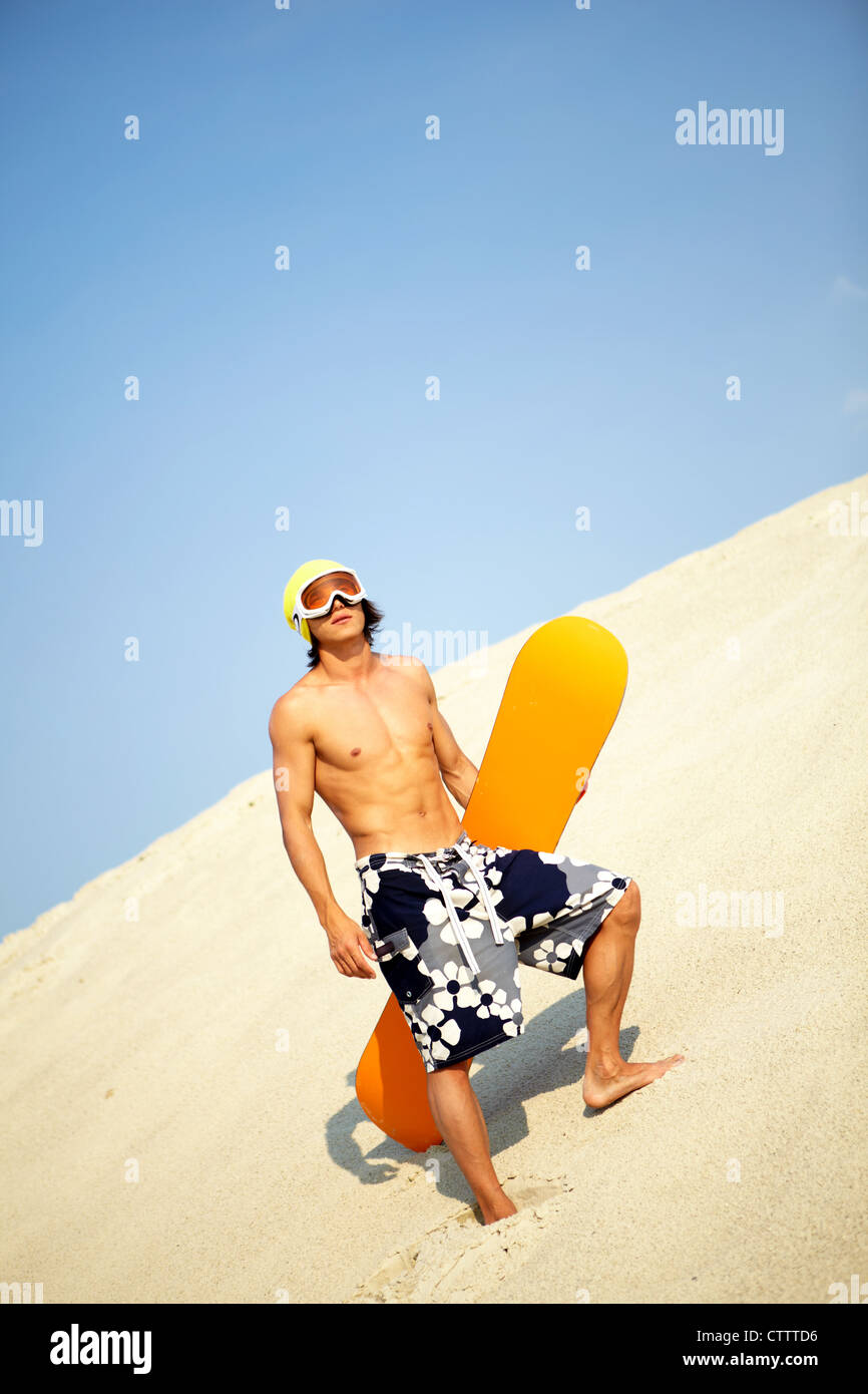 Vertical image of a muscular young man sandboarding Stock Photo - Alamy