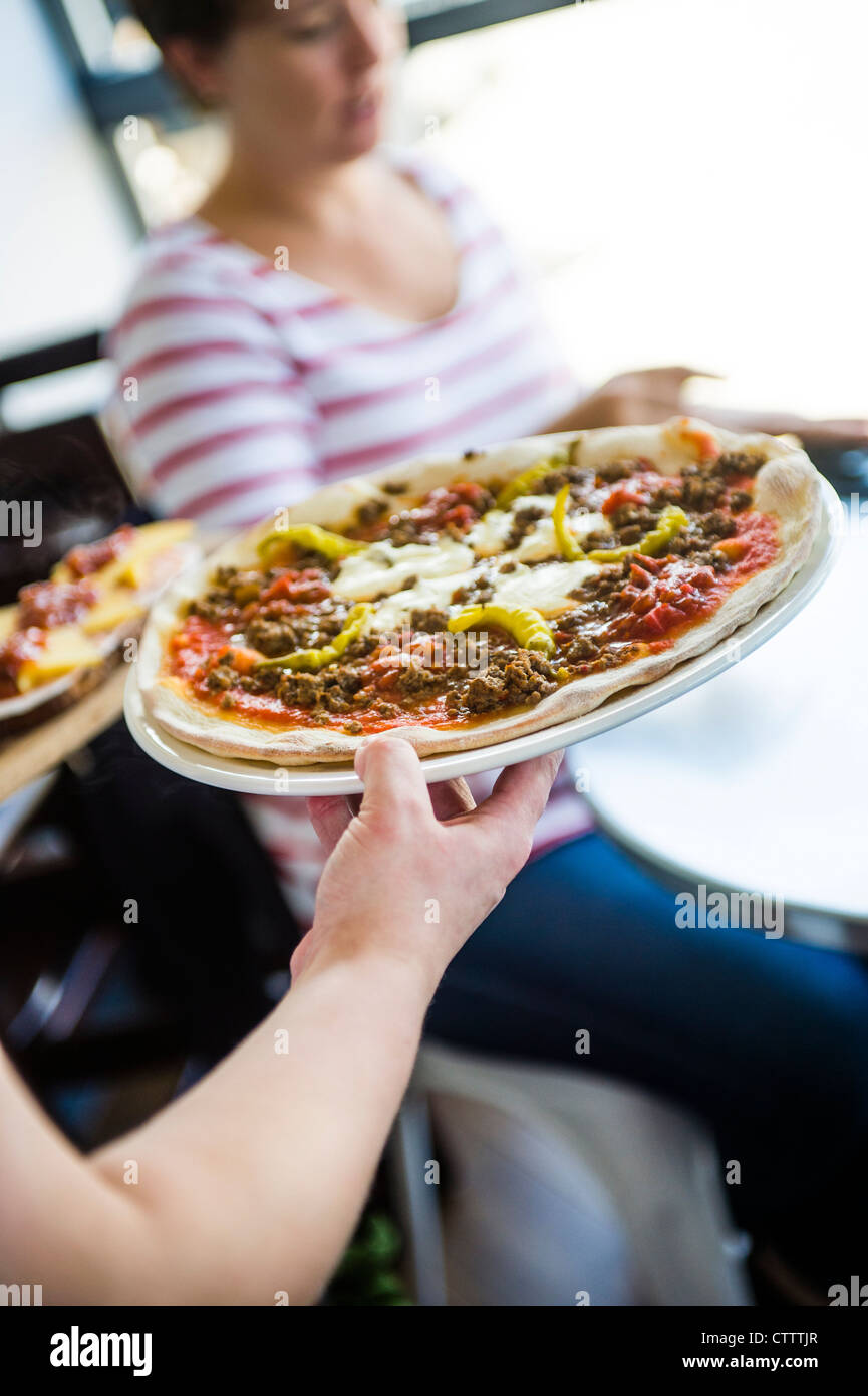 a waitress serving Fresh hand made pizza in BARAVIN, a new pizzeria ...