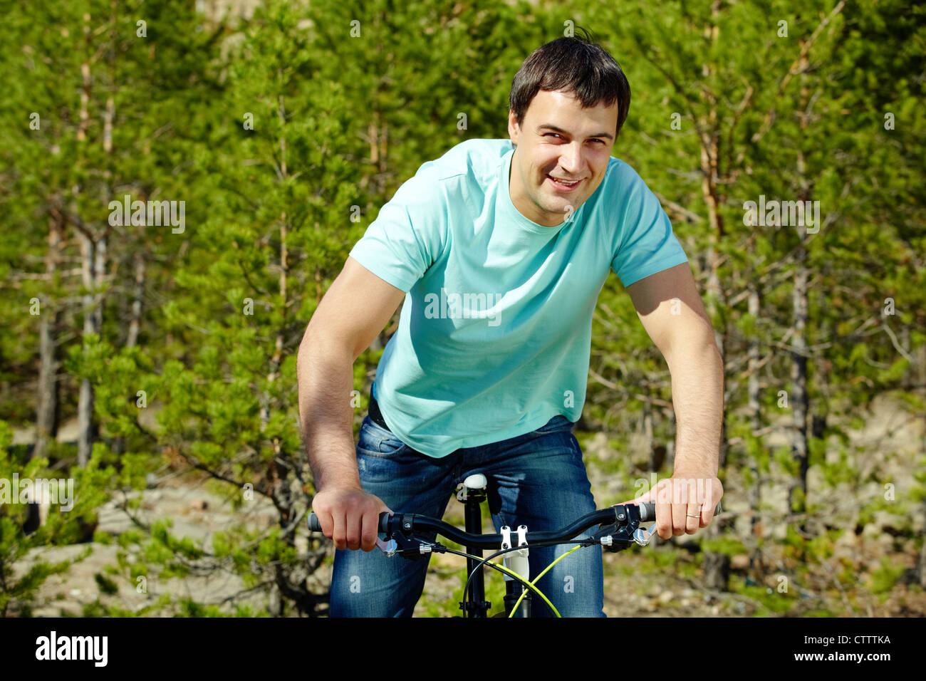 Portrait of a handsome man riding a bike Stock Photo - Alamy