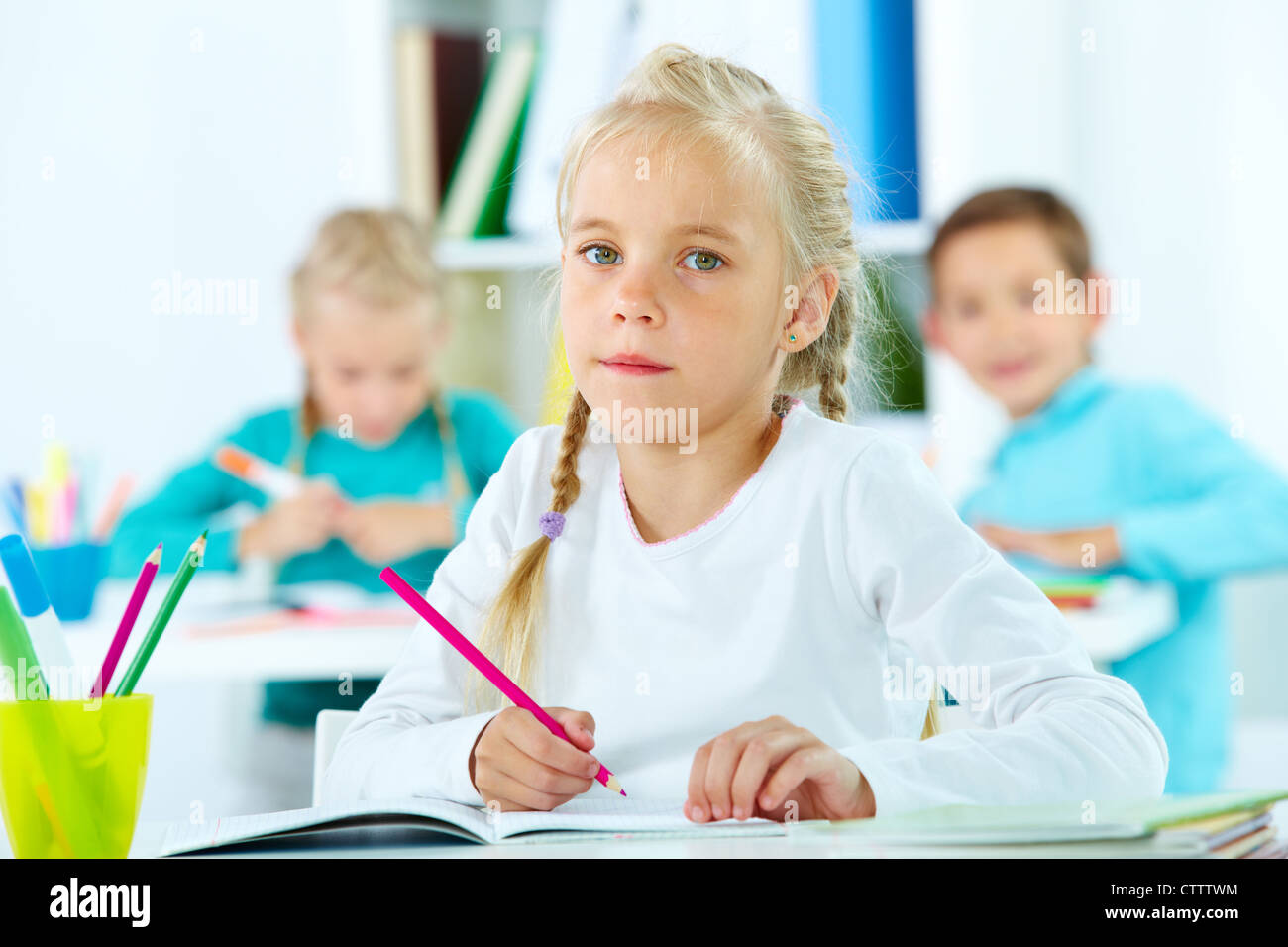 Portrait of lovely girl drawing with classmates on background Stock ...