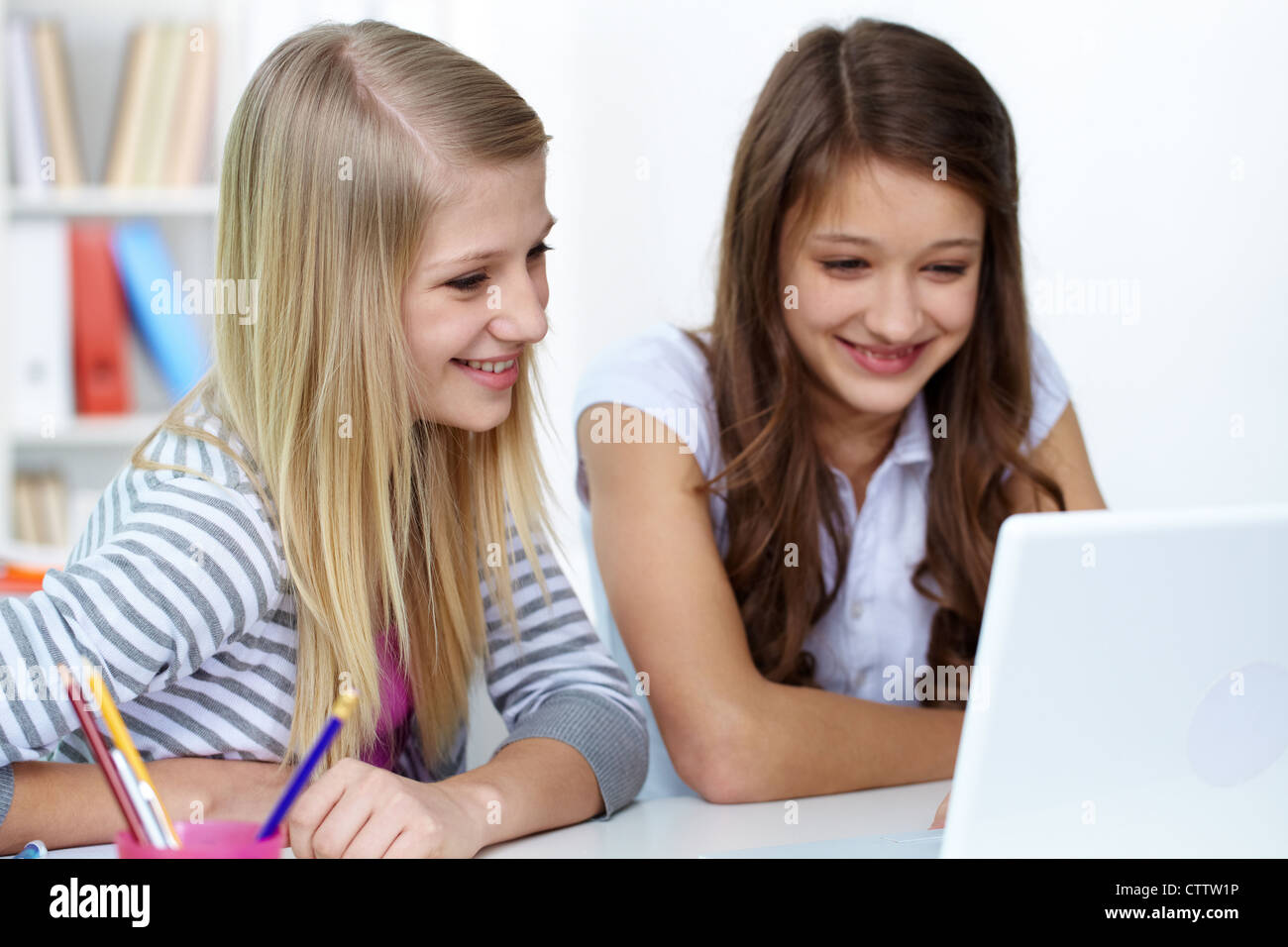 Cute girls working with laptop in college Stock Photo - Alamy