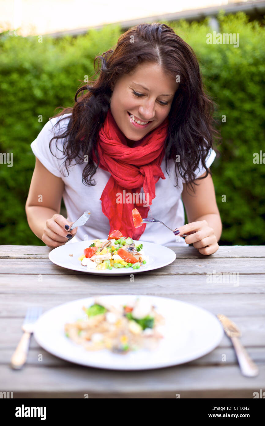 Portrait of a woman looking down as she enjoys eating her lunch Stock ...