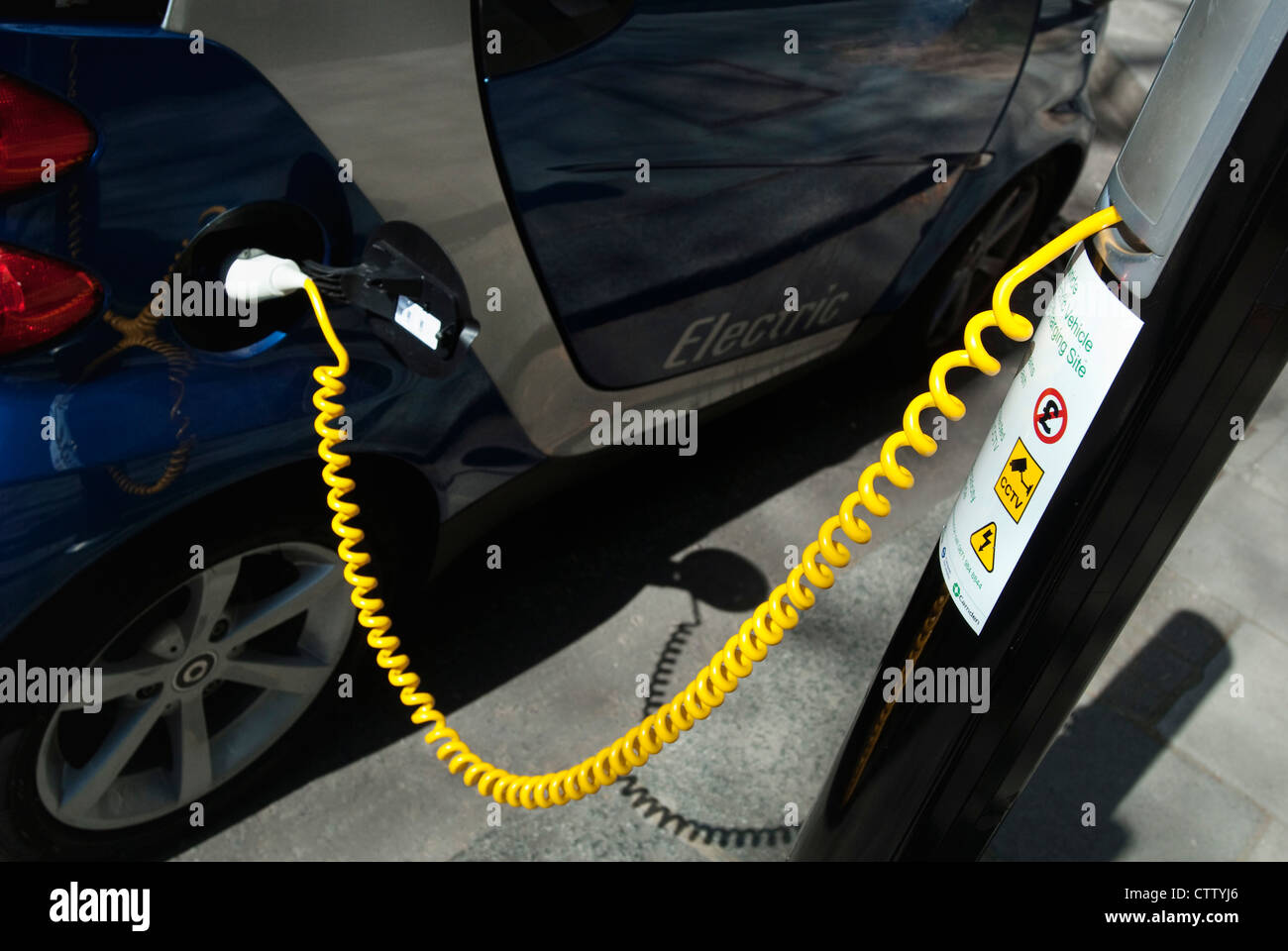 Electric car receiving a charge from a special allocated city parking ...