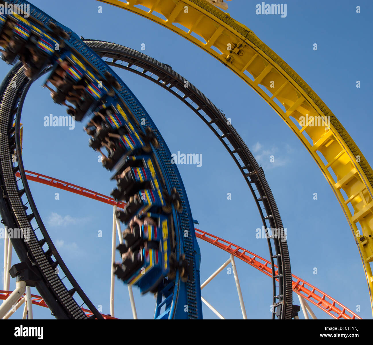 Rollercoaster in a looping against blue sky Stock Photo - Alamy