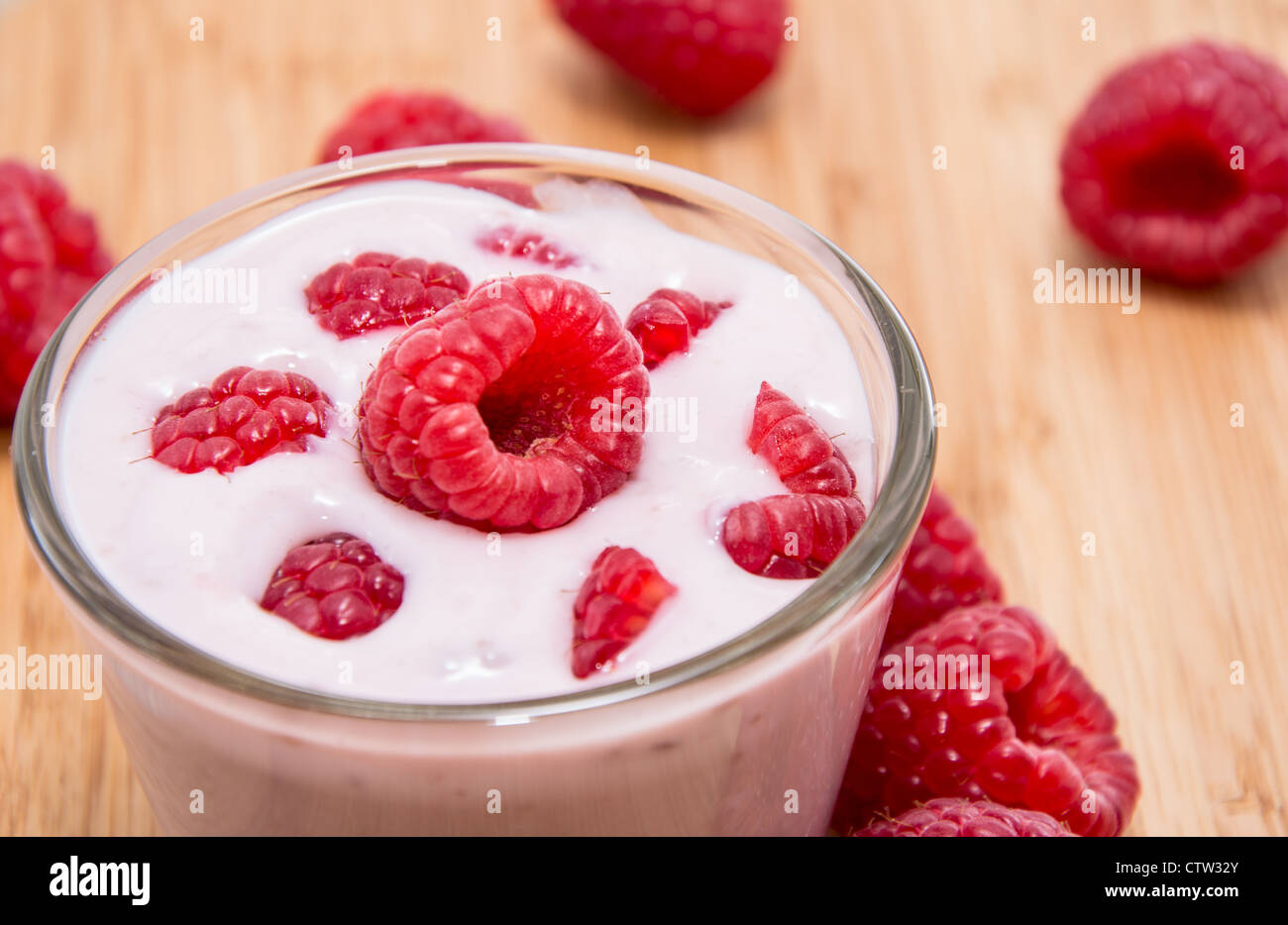 Raspberry Yogurt on wooden background Stock Photo - Alamy