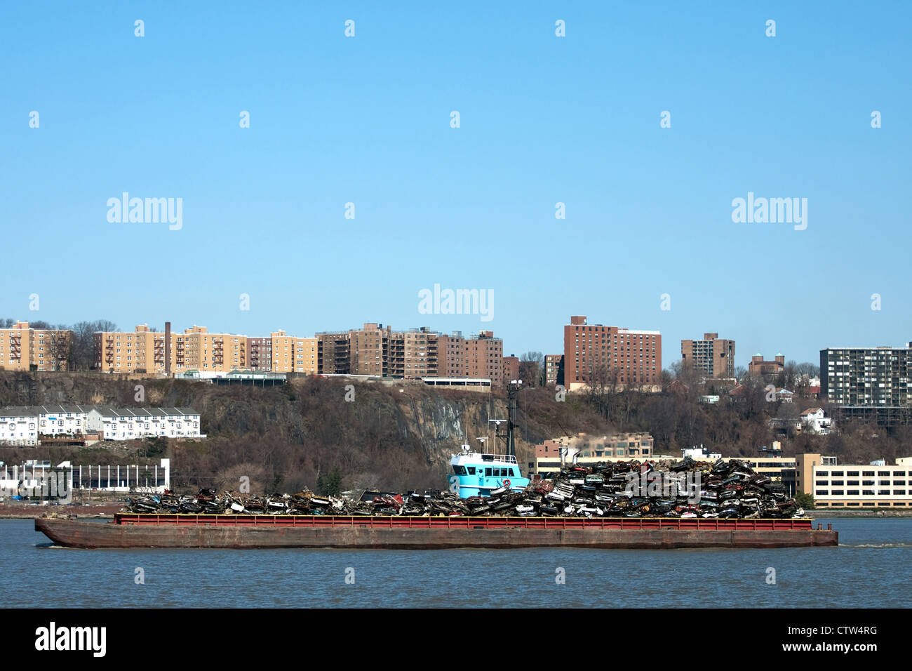 A large boat floating down the river carries scrap metal and crushed ...