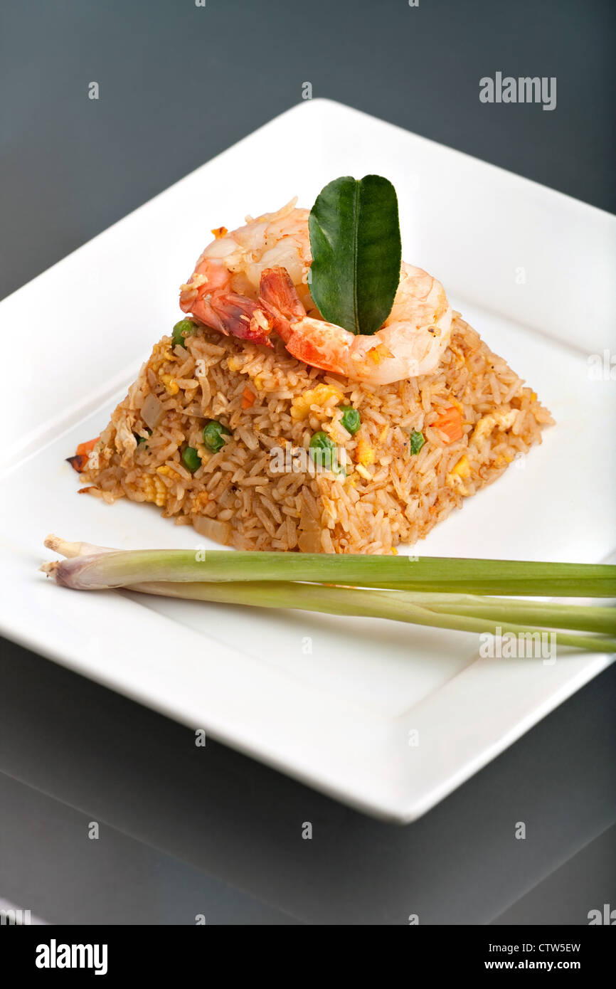 A Thai dish of shrimp fried rice presented on a square white plate in ...