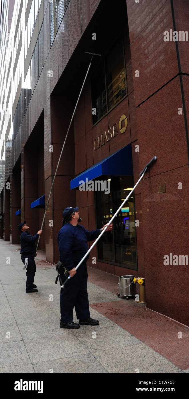 Sidewalk portrait two men with telescopic squeegees cleaning brown ...