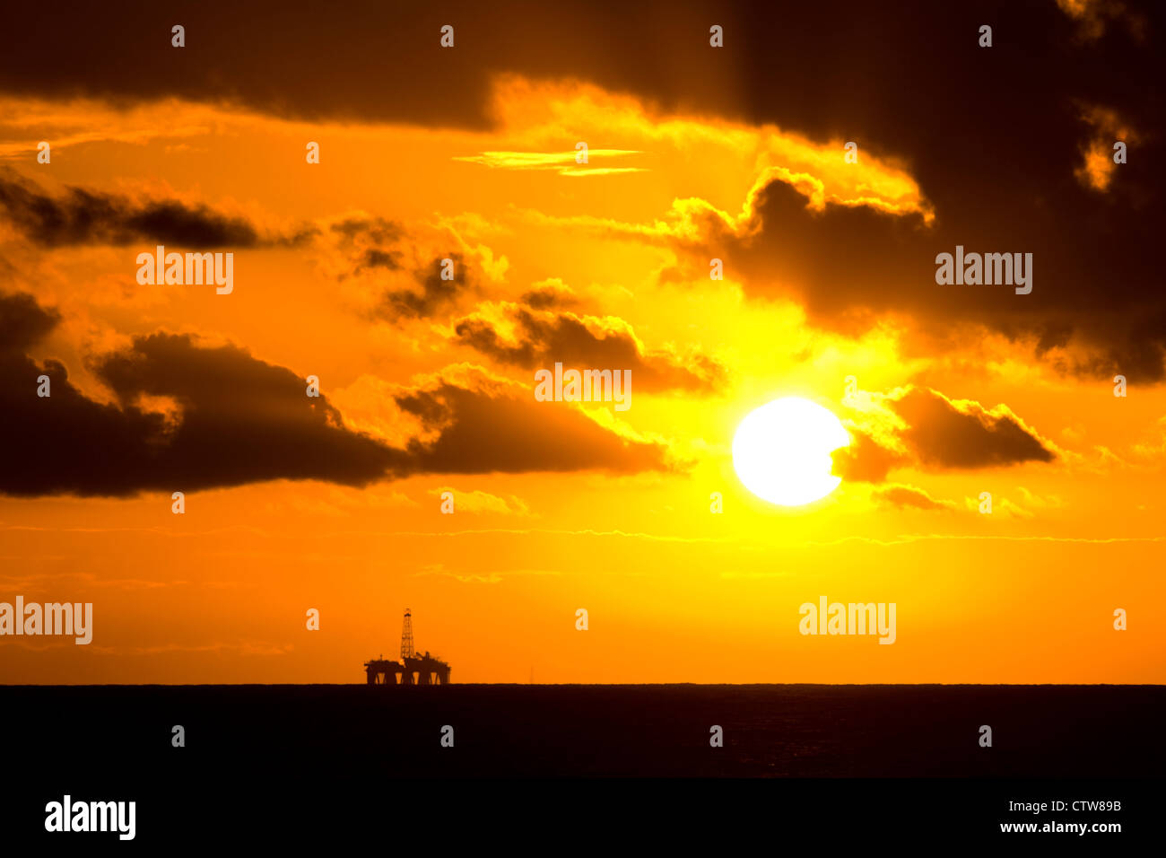 Silhouette of an oil drilling rig in offshore area, during sunset ...