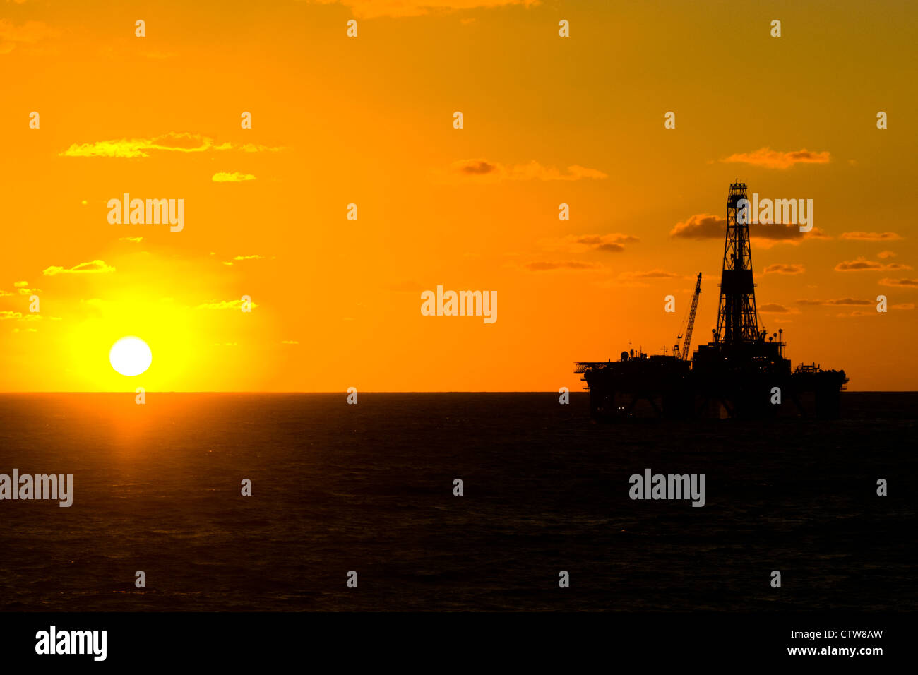 Silhouette of an oil drilling rig in offshore area, during sunset ...