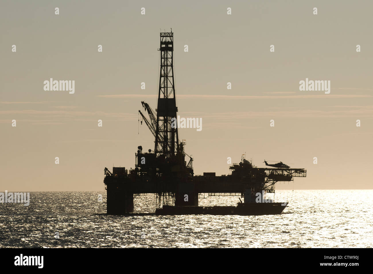 silhouette of an offshore oil drilling rig. Helicopter landed and ...