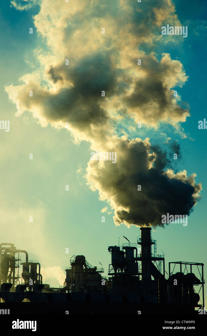 Smoking chimney at sunset on industrial buildings complex Stock Photo ...