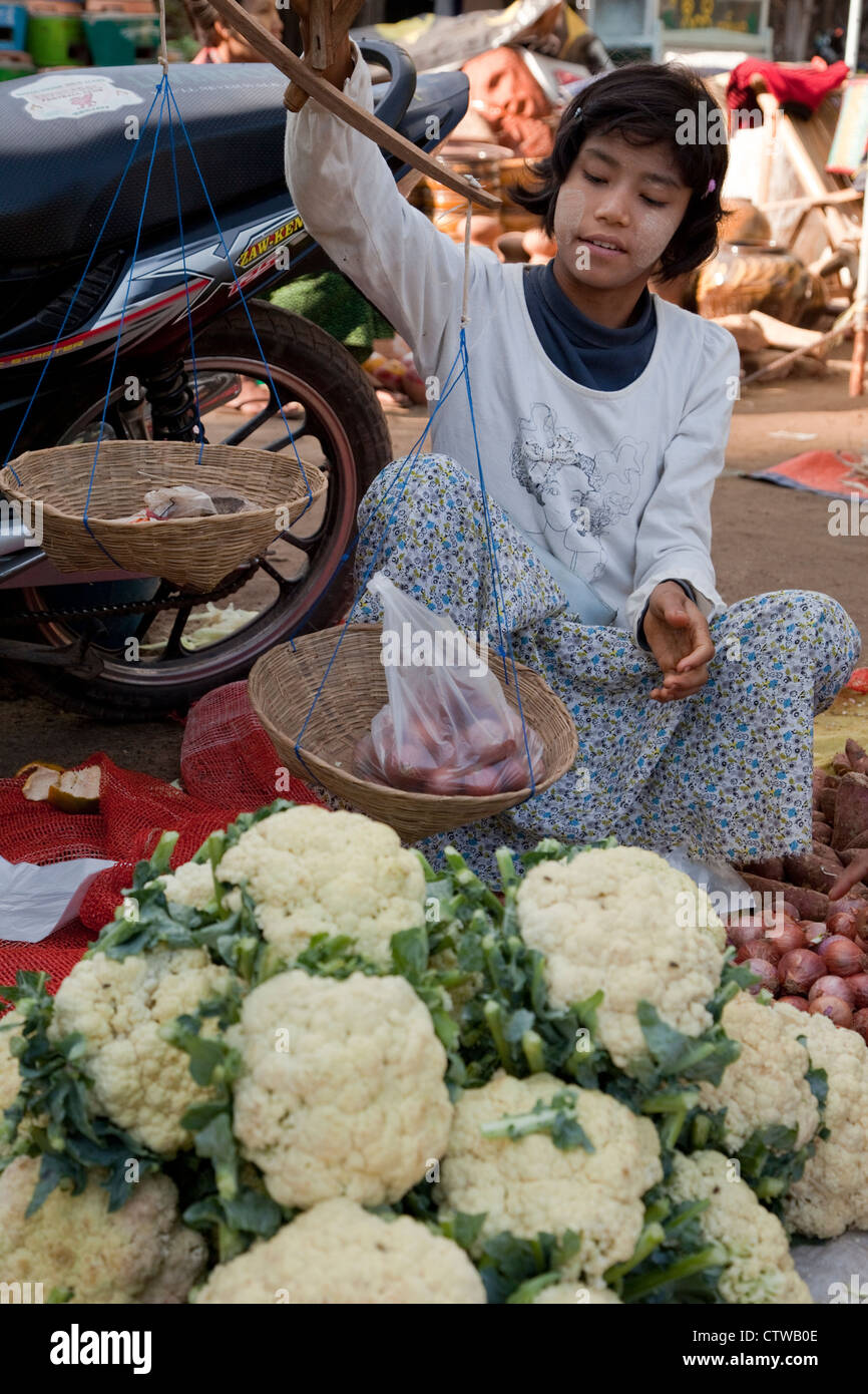 Myanmar, Burma. Young Woman Weighing Onions in a Hand-held Scale. Bagan ...