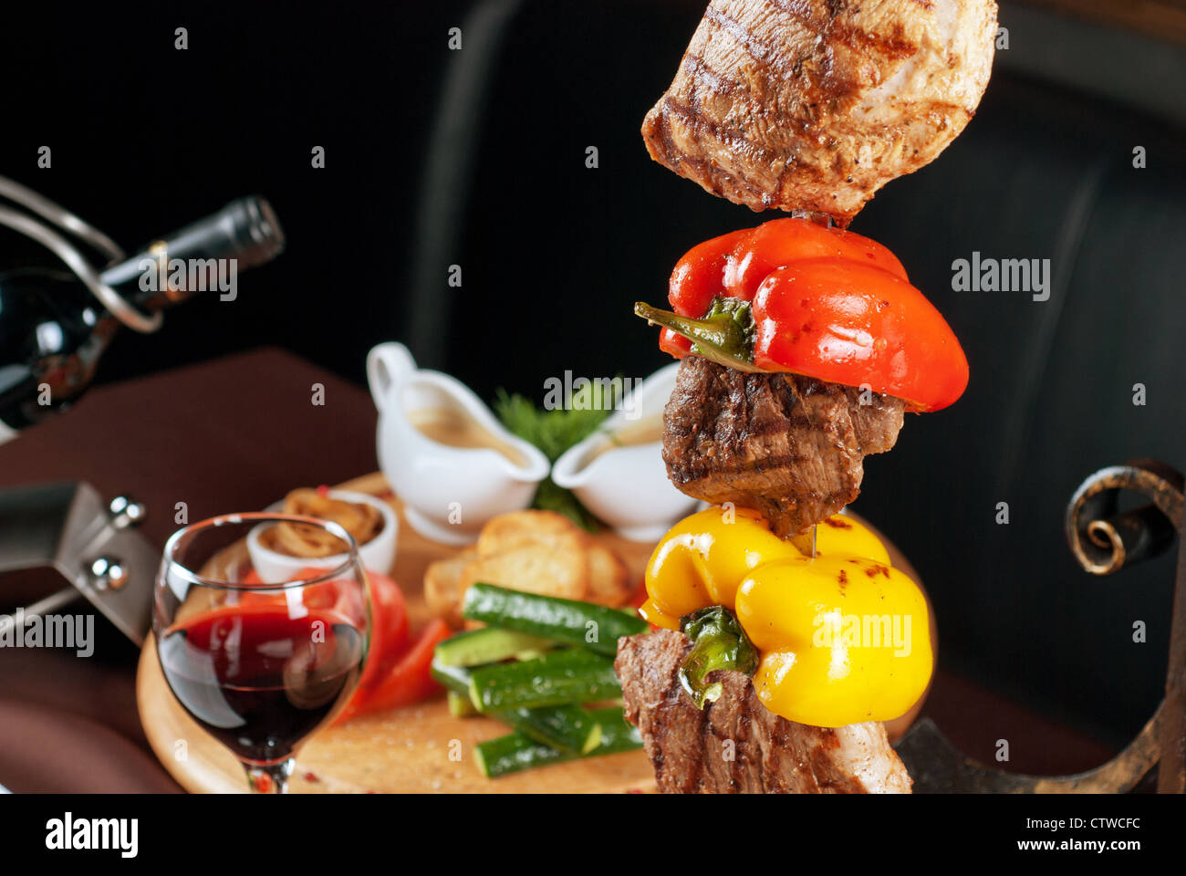 Big tasty roasted meat cuts at skewer on a decorated table Stock Photo ...