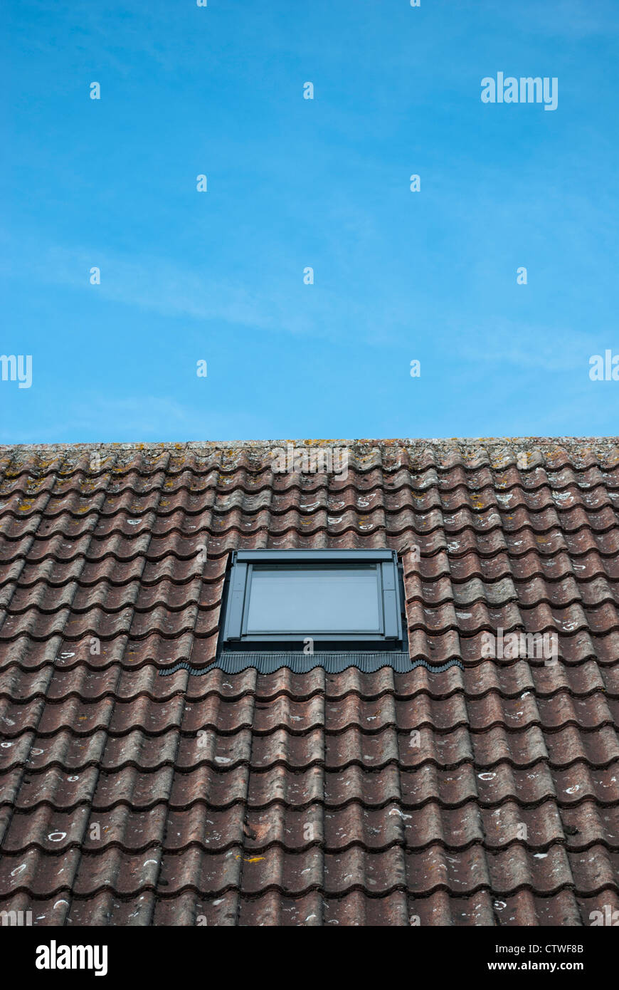 Velux skylight window in a tiled roof against a bright blue sky Stock ...