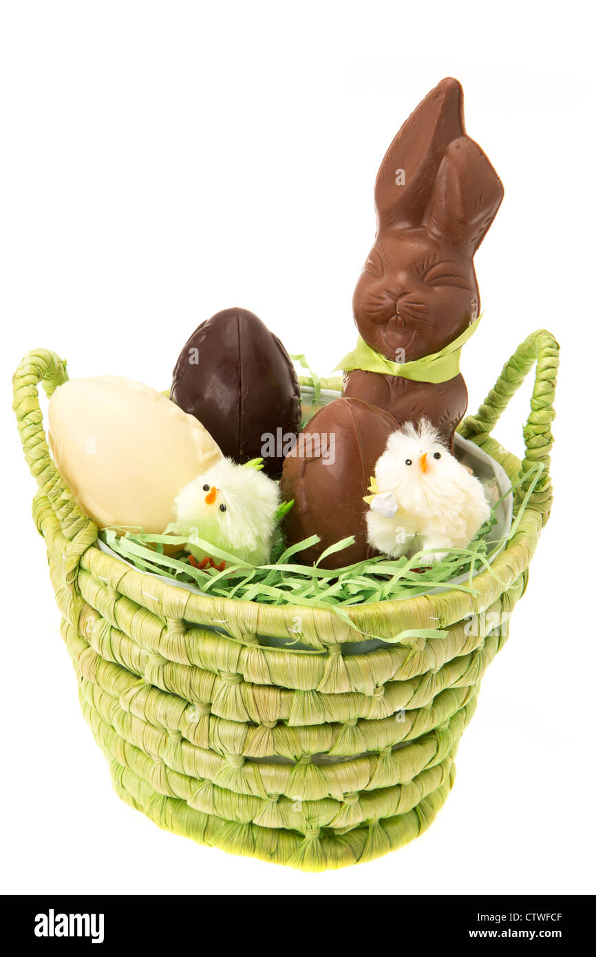 A straw basket containing chocolate Easter eggs and a chocolate Easter ...