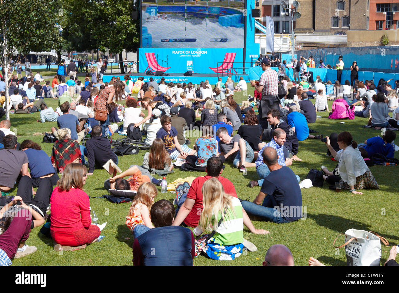 Spectators watch a large outdoor screen showing London 2012 Olympic ...