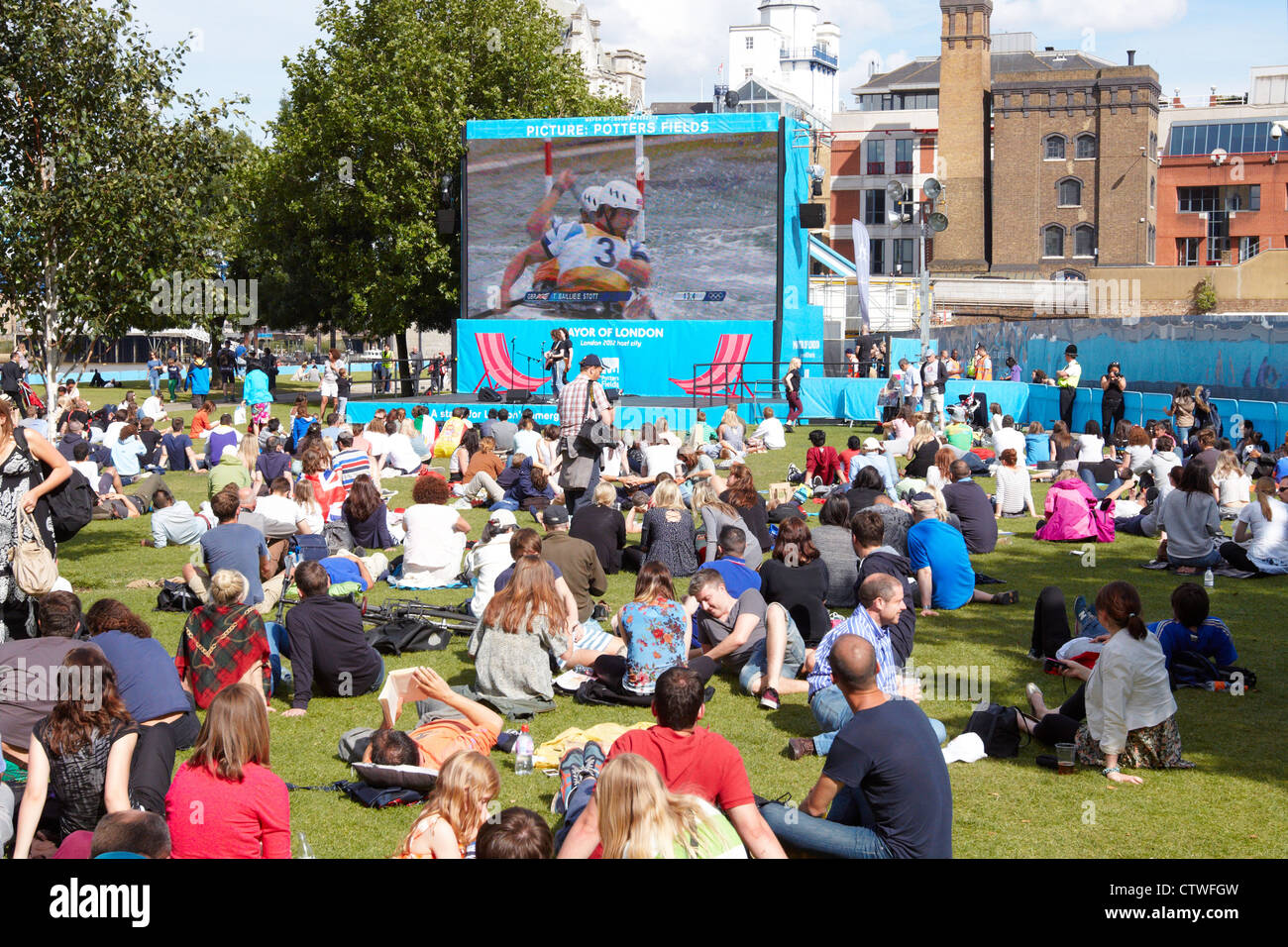 Spectators watch a large outdoor screen showing London 2012 Olympic ...