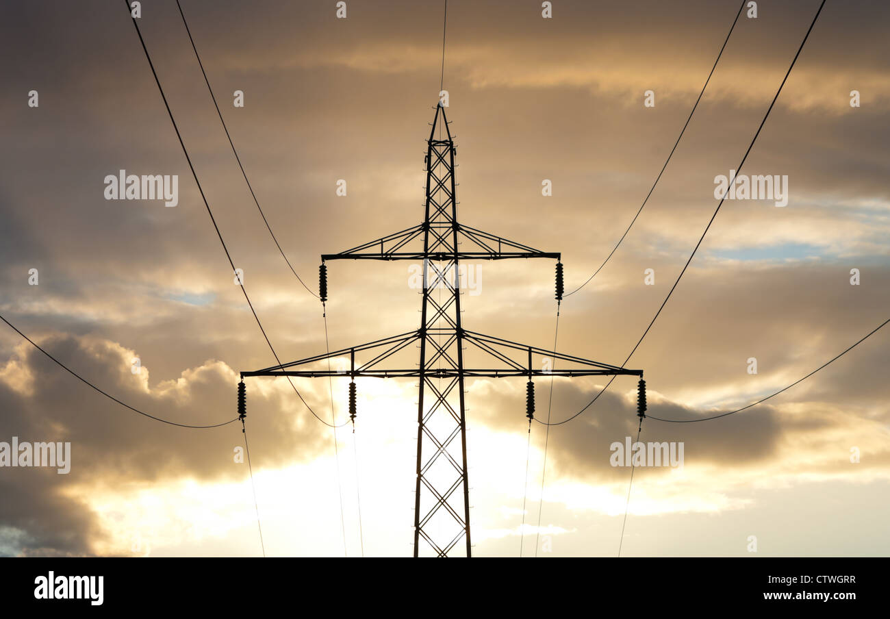 electricity pylons against a nice yellow orange sunset Stock Photo - Alamy