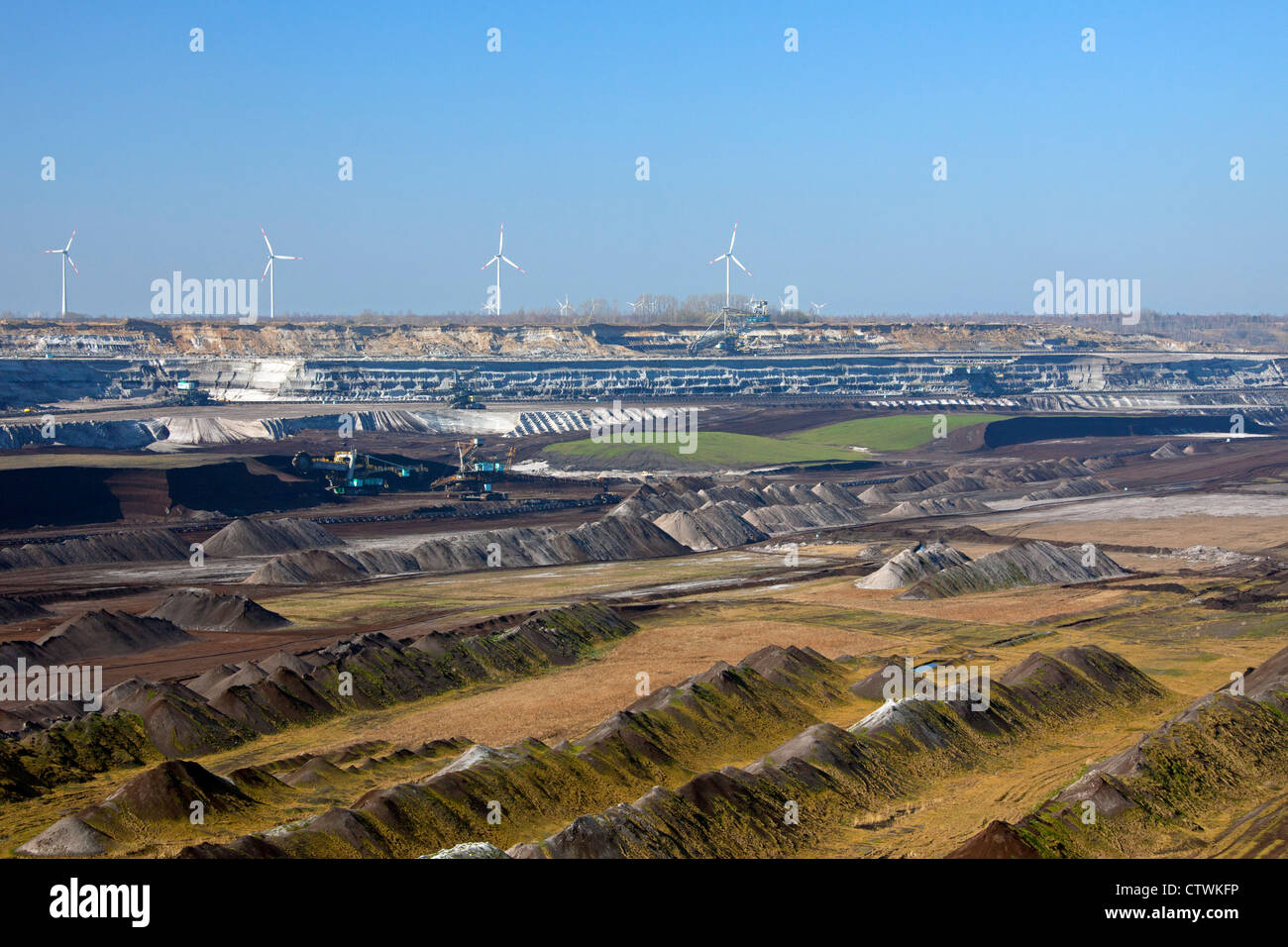 Spoil heaps and brown coal / lignite being extracted by huge bucket ...