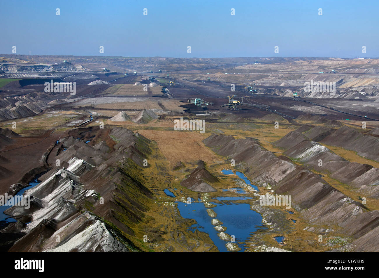Spoil heaps and brown coal / lignite being extracted by huge bucket ...