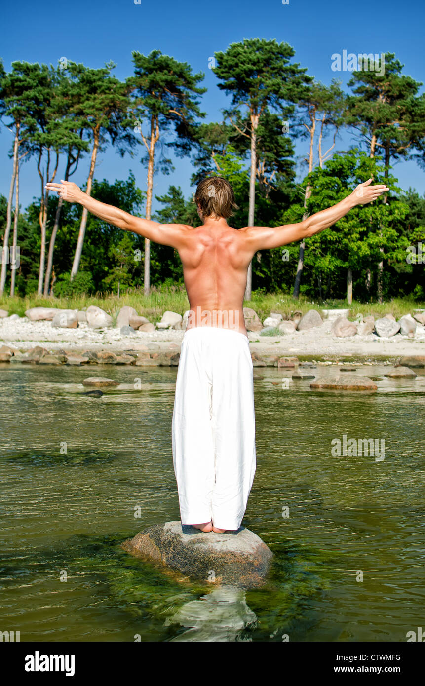 Man doing meditation exercises on the beach Stock Photo - Alamy