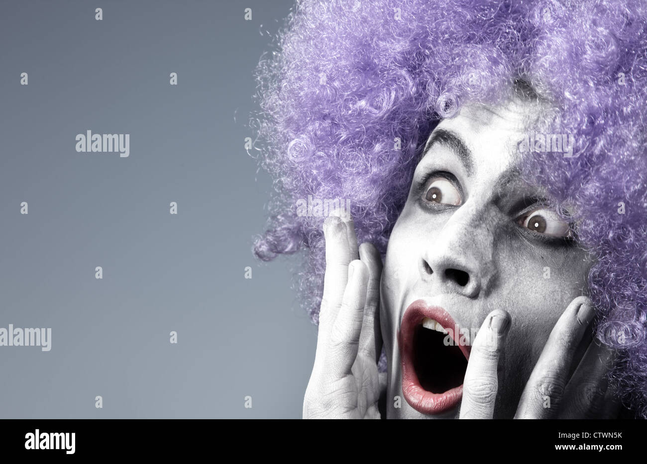 Afraid clown on a blue background Stock Photo - Alamy