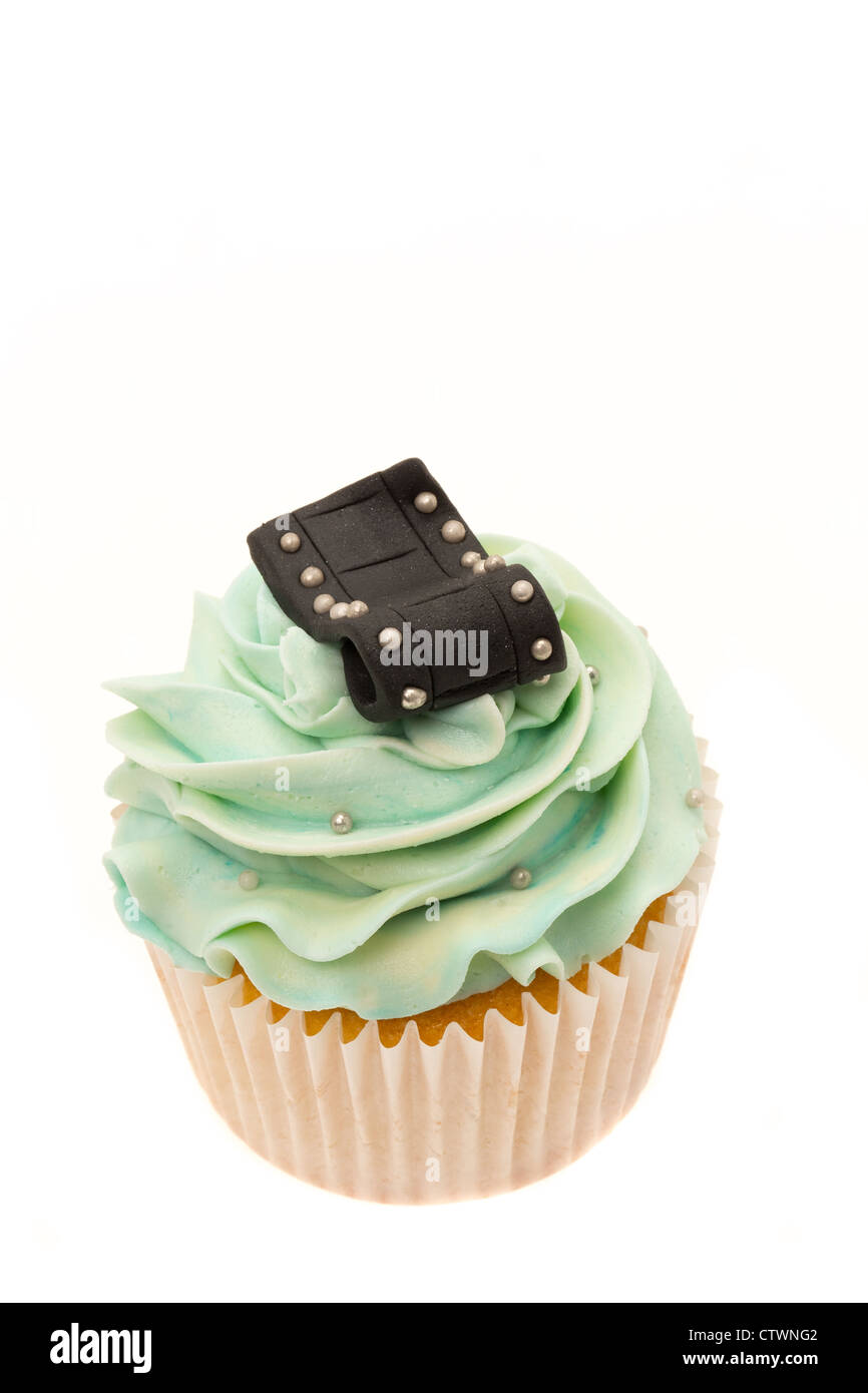 A cupcake with a roll of camera film made from fondant icing placed on ...