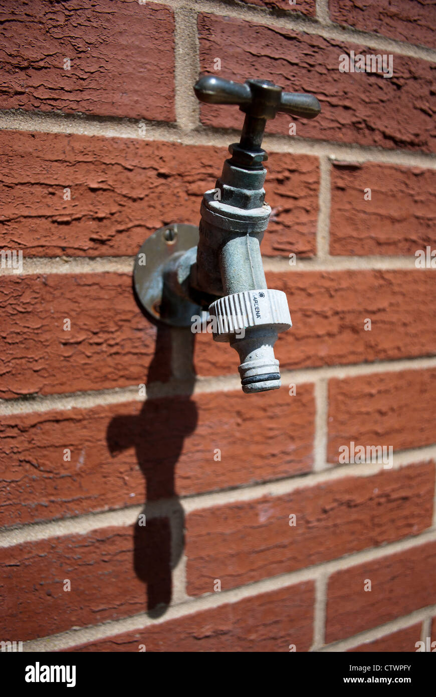 Water tap mounted in red brick wall Stock Photo - Alamy