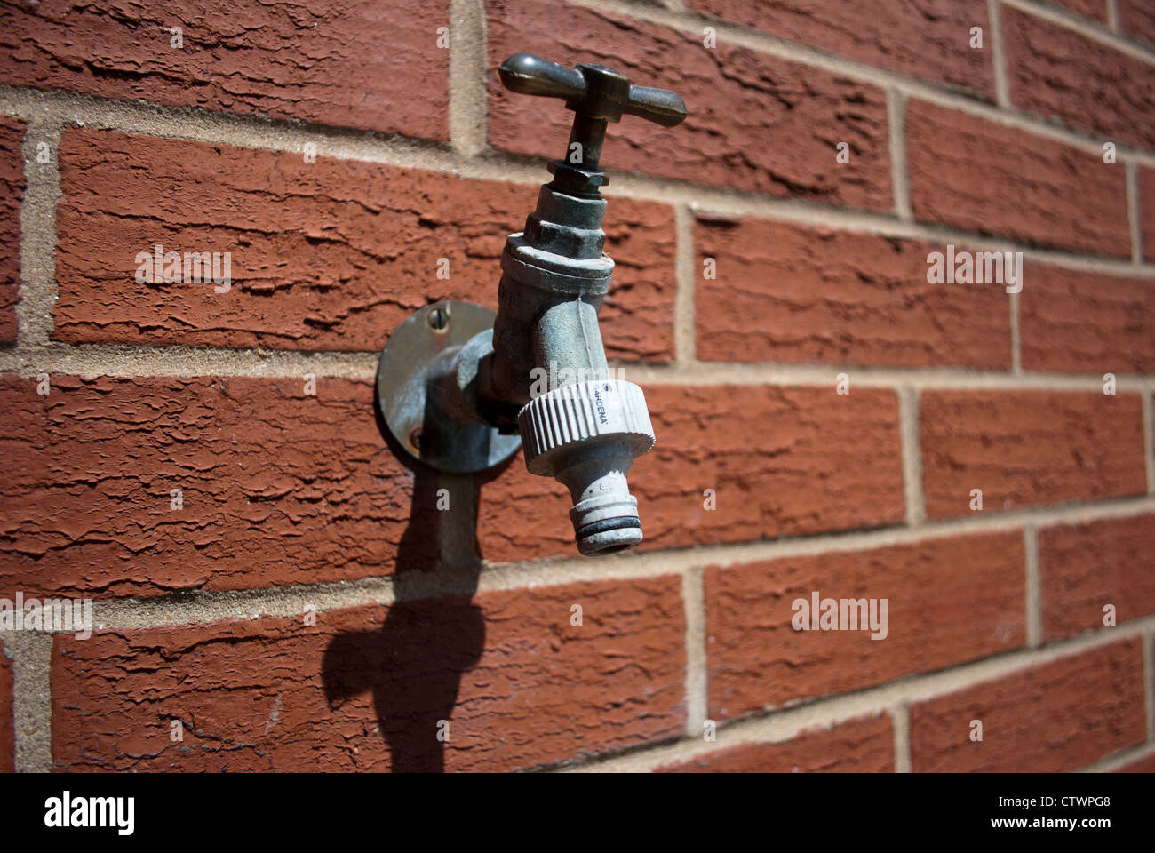 Water tap mounted in red brick wall Stock Photo - Alamy