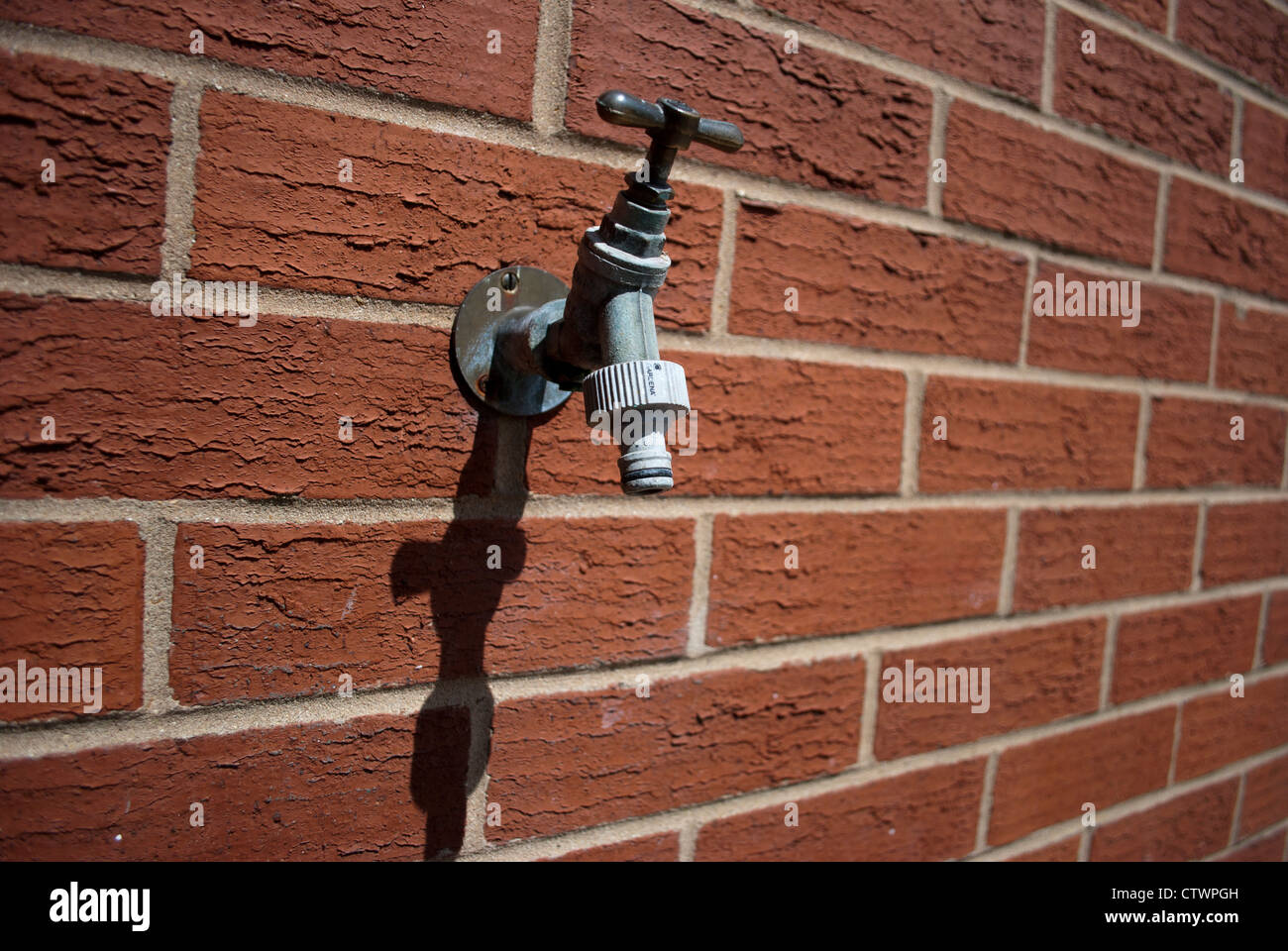 Water tap mounted in red brick wall Stock Photo - Alamy