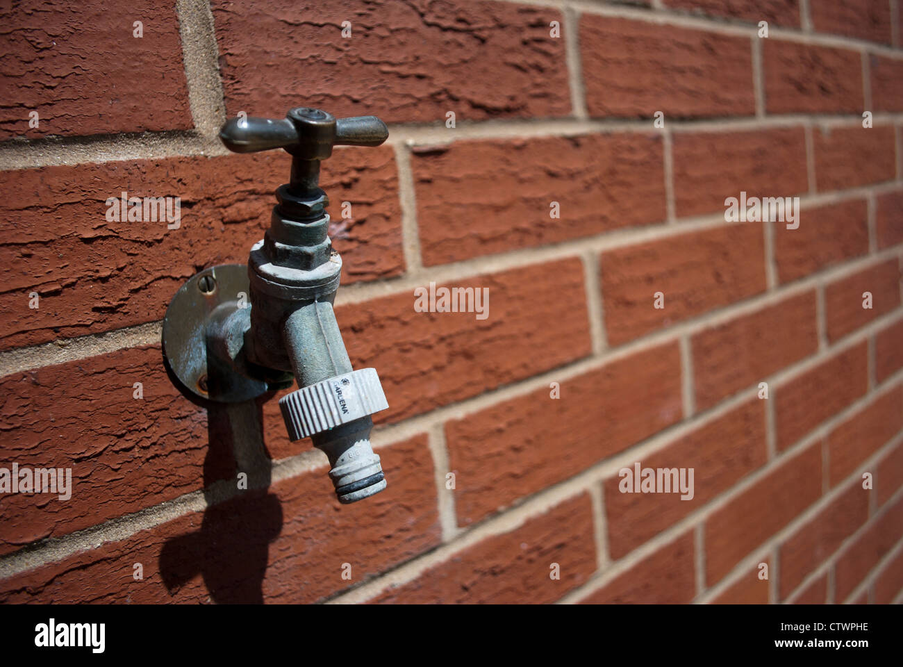 Water tap mounted in red brick wall Stock Photo - Alamy