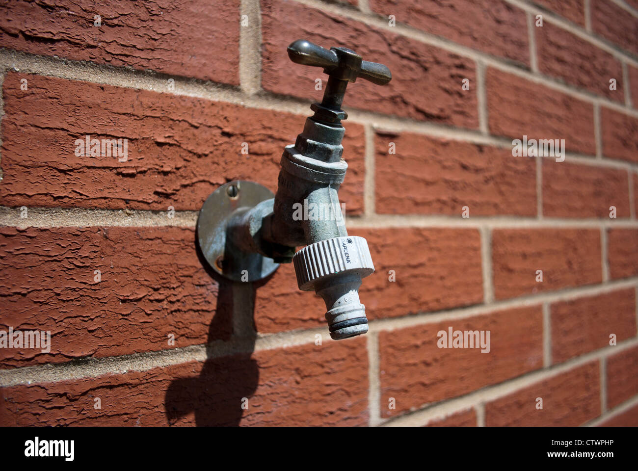 Water tap mounted in red brick wall Stock Photo - Alamy