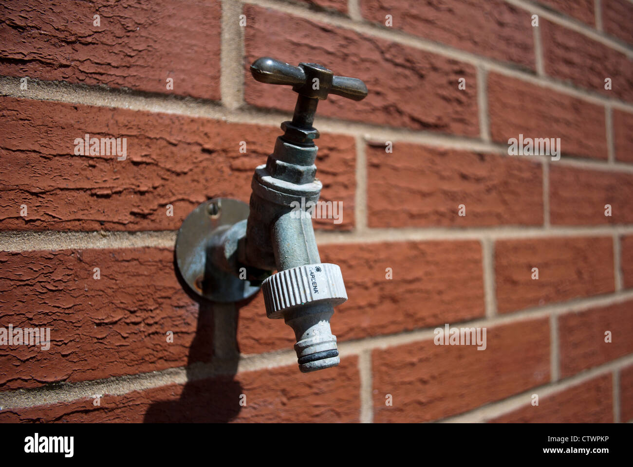Water tap mounted in red brick wall Stock Photo - Alamy