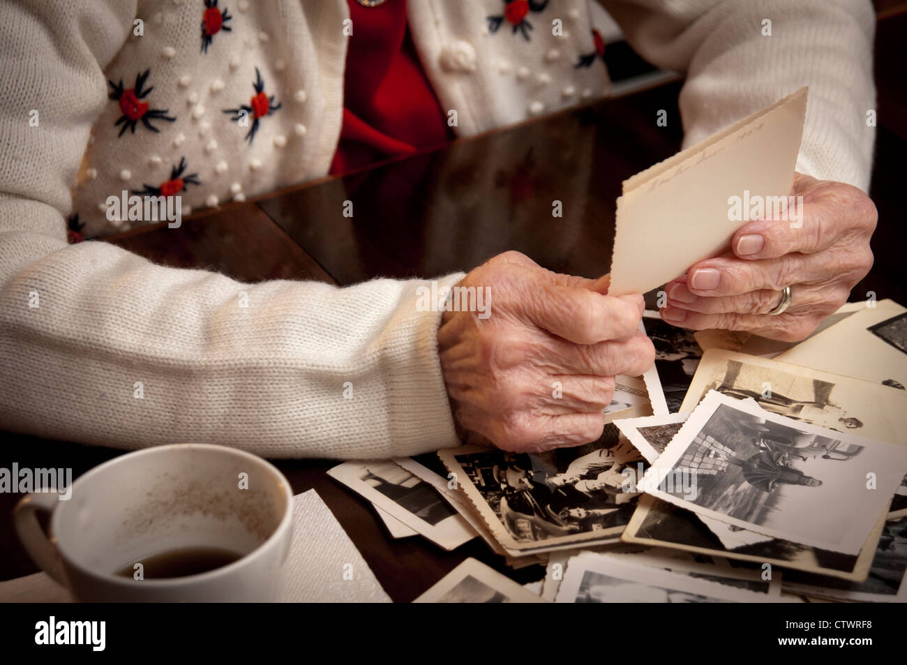 Elderly woman holding an old picture and reminiscing Stock Photo - Alamy