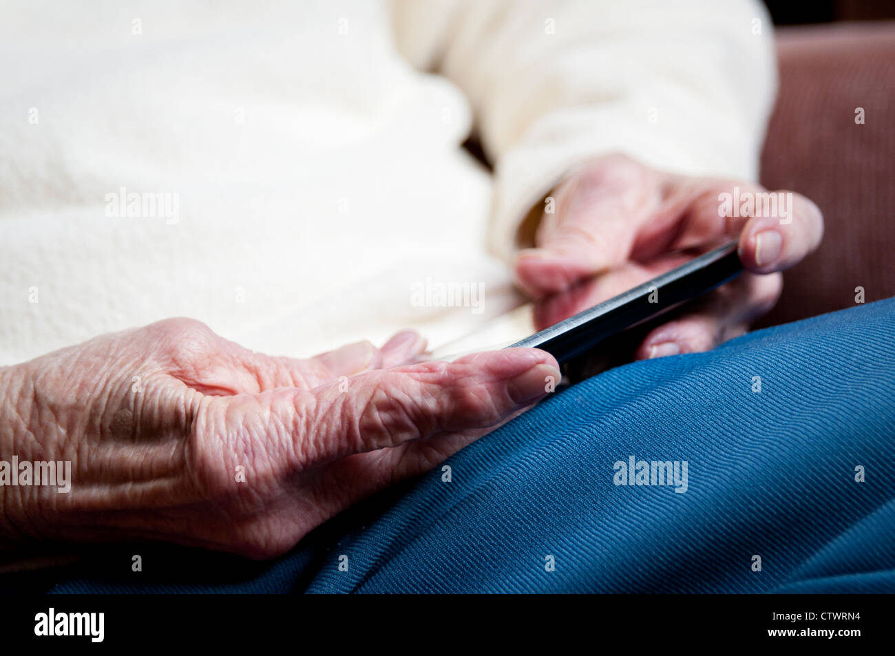 Close-up of elderly woman's hands texting and using apps on her iPhone ...