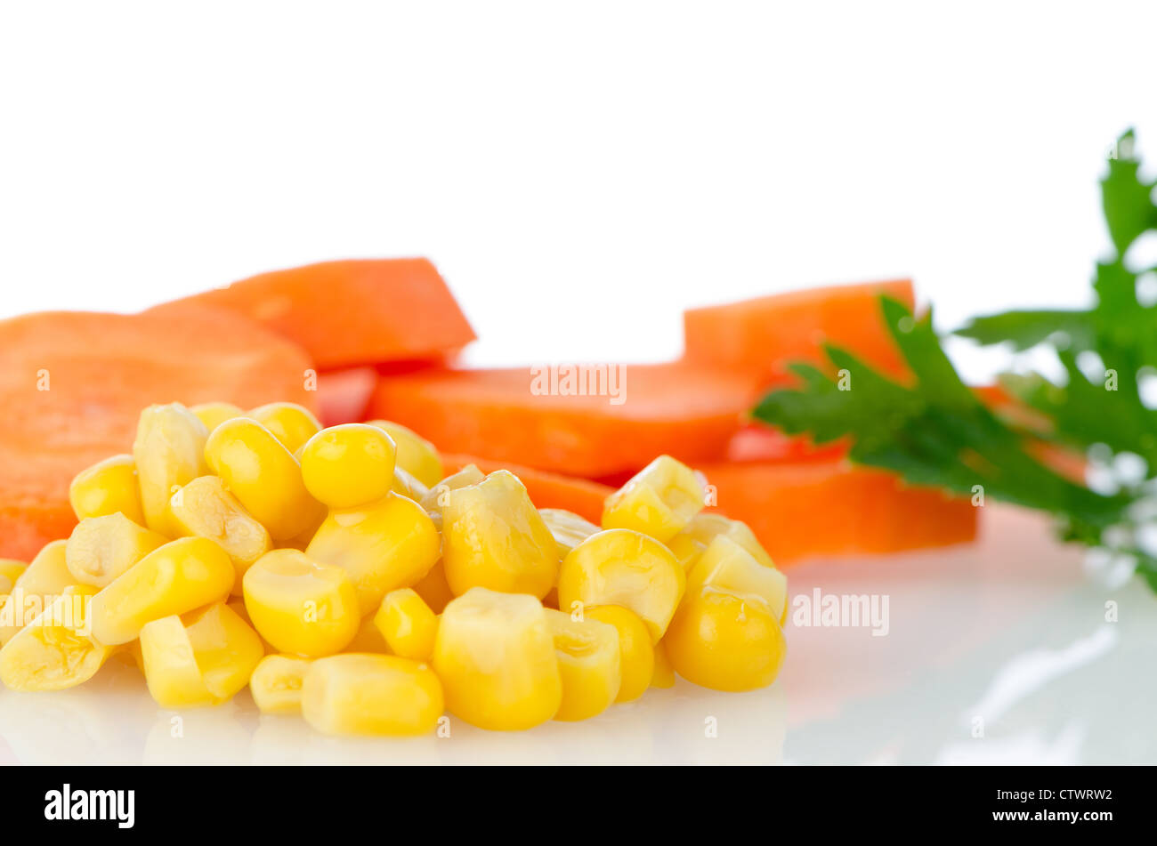 Corn grains and carrot slices on white background Stock Photo - Alamy