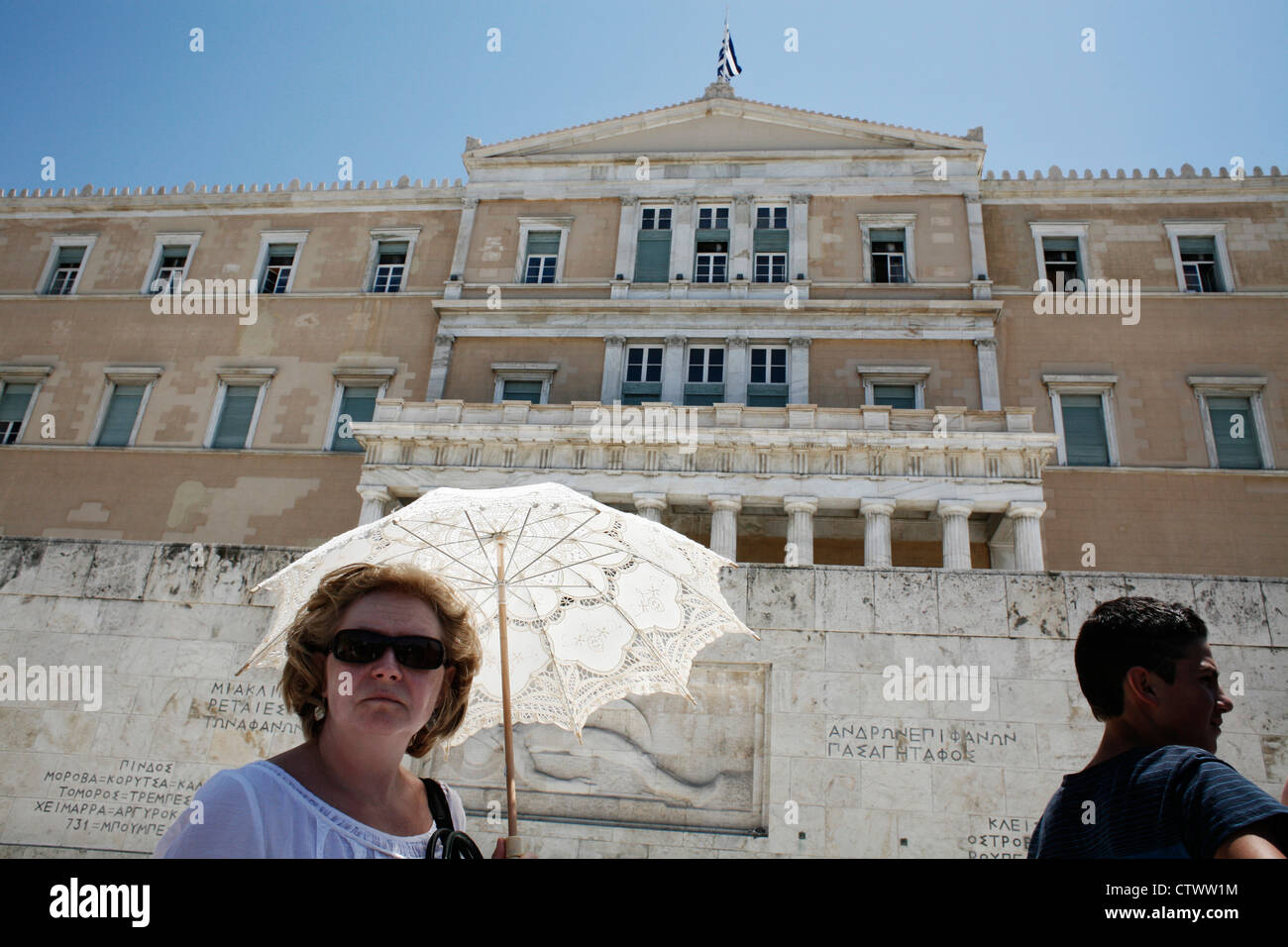 Heat wave in Athens. Tourist protected from the sun with an umbrella in ...