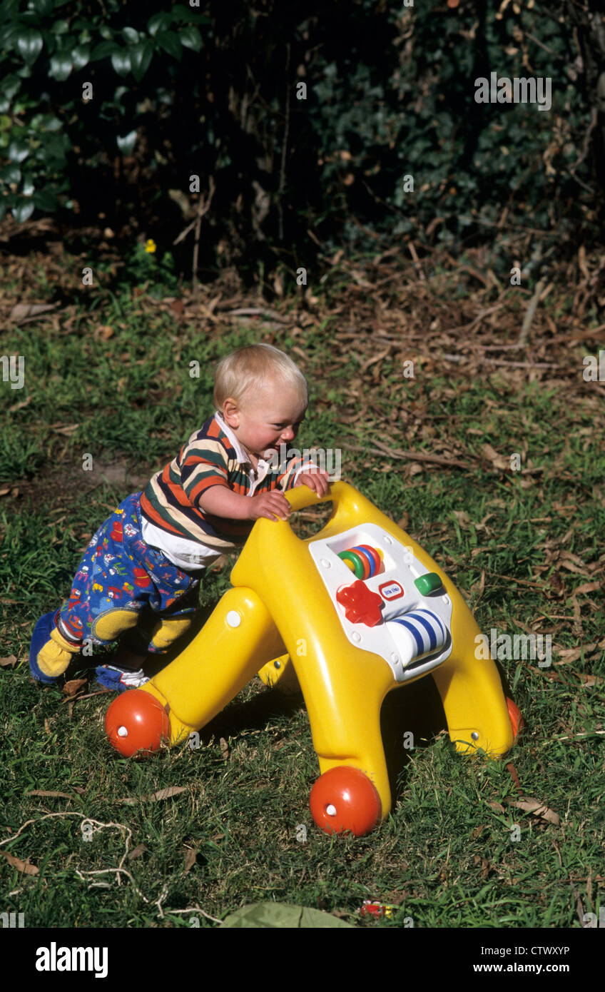 Infant using baby walker to stand up Stock Photo - Alamy