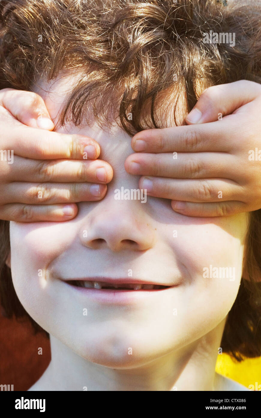 A boy with both eyes covered Stock Photo - Alamy