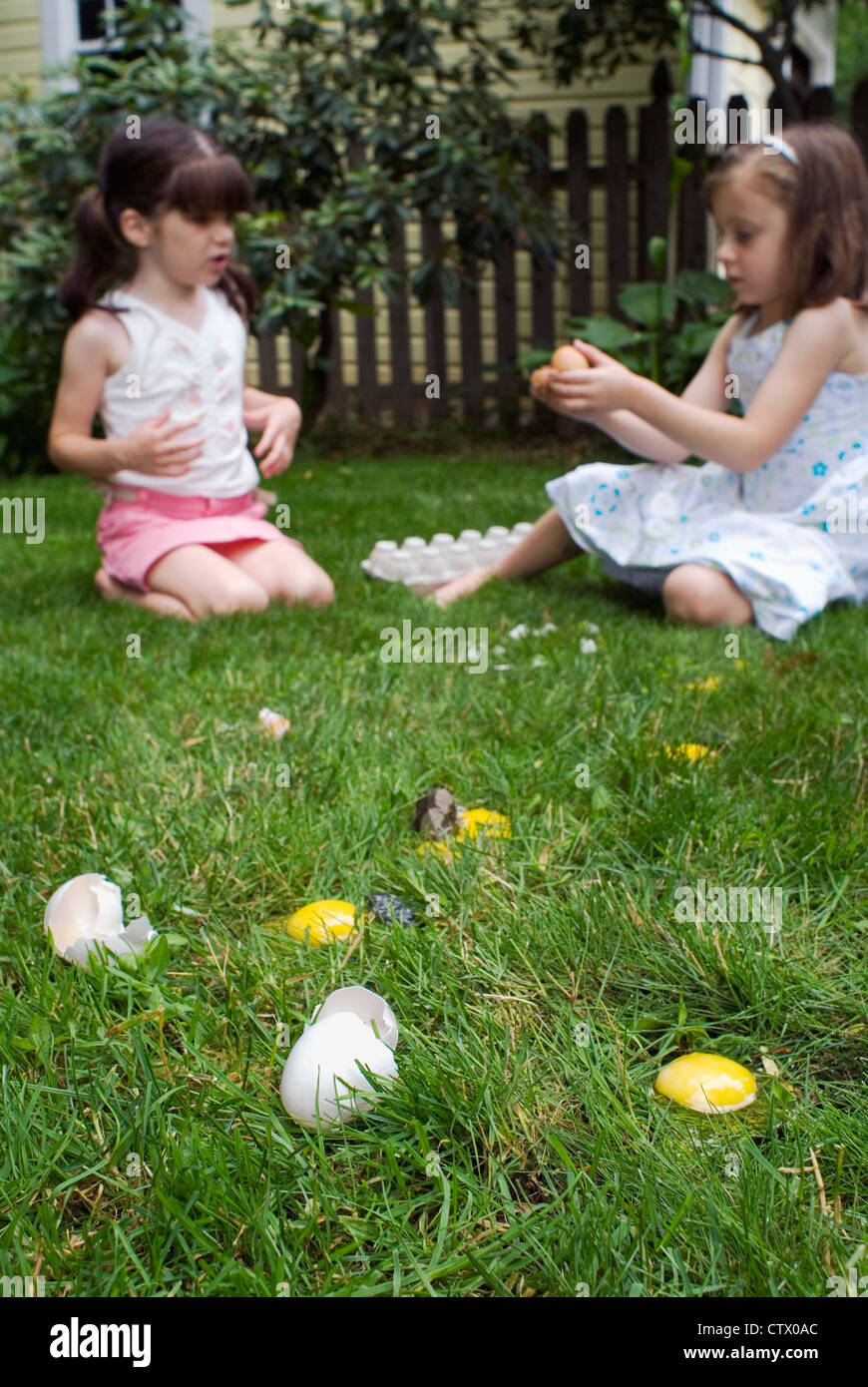 Two girls playing with and breaking eggs Stock Photo - Alamy