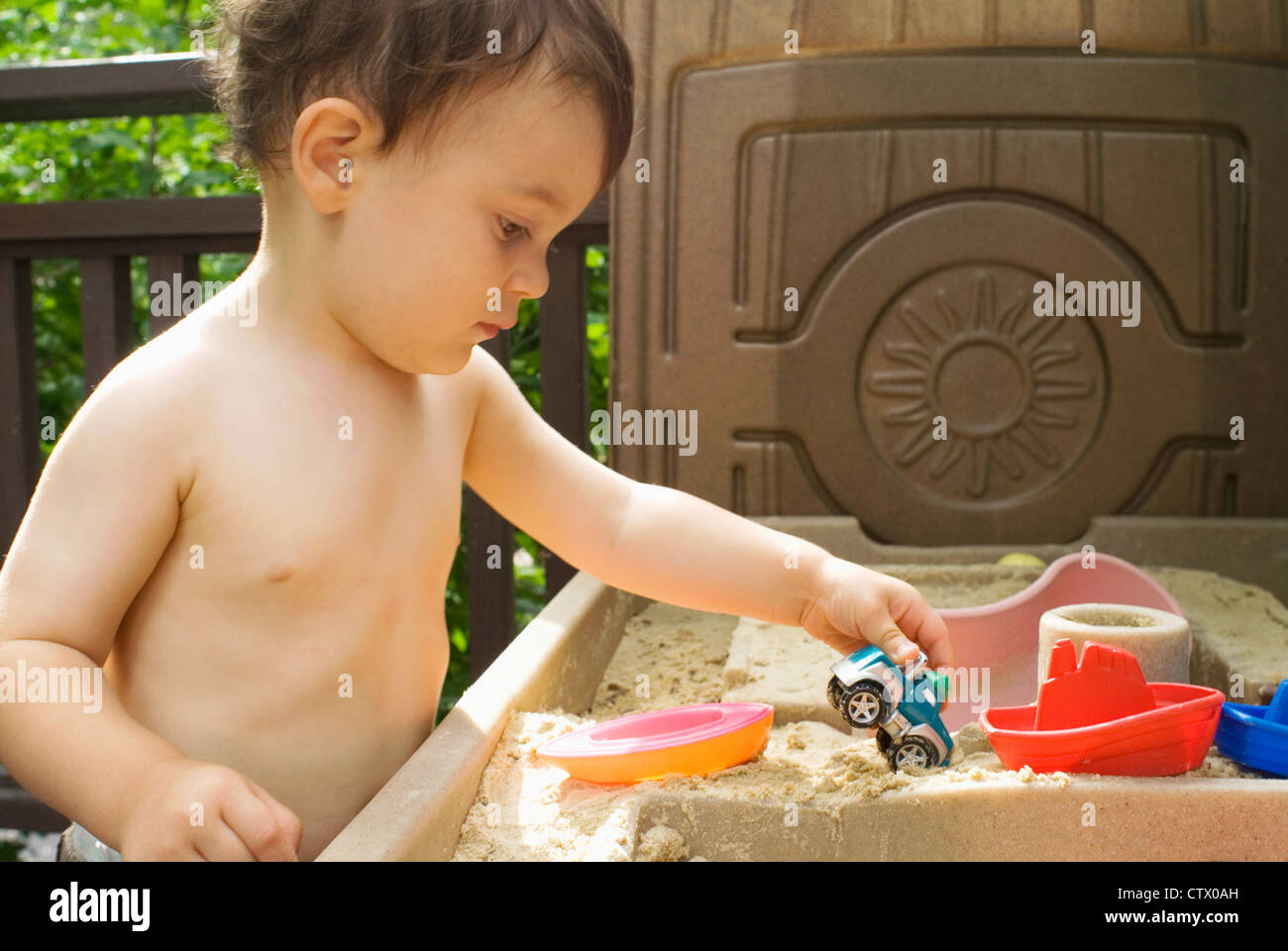 A boy playing in a sandbox Stock Photo - Alamy