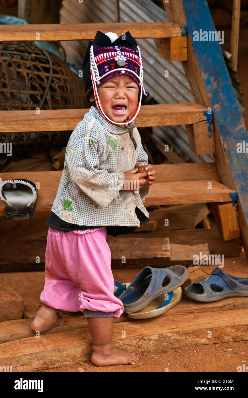 A baby girl of the AKHA tribe wears a childs headdresse made of beads ...
